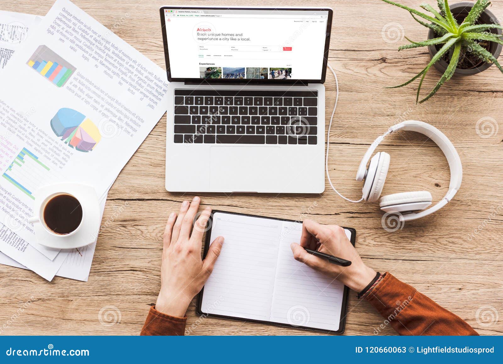 Partial View of Man Making Notes in Notebook at Workplace with Laptop ...