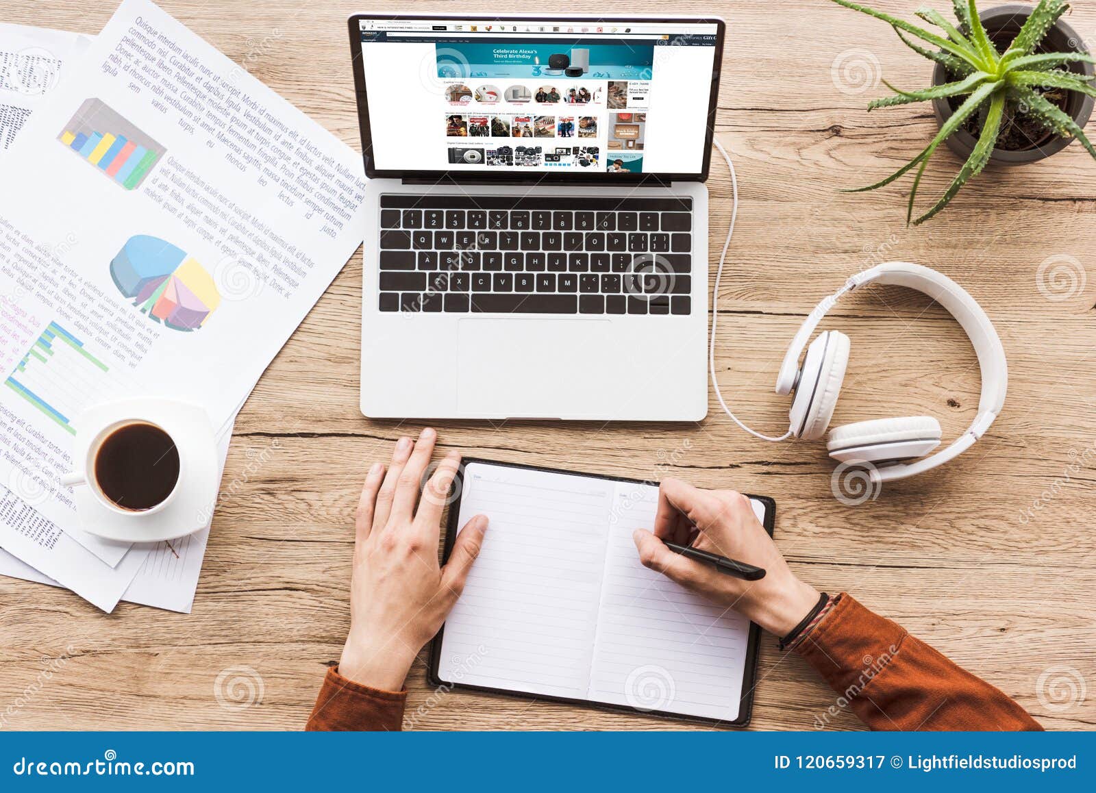 Partial View of Man Making Notes in Notebook at Workplace with Laptop ...