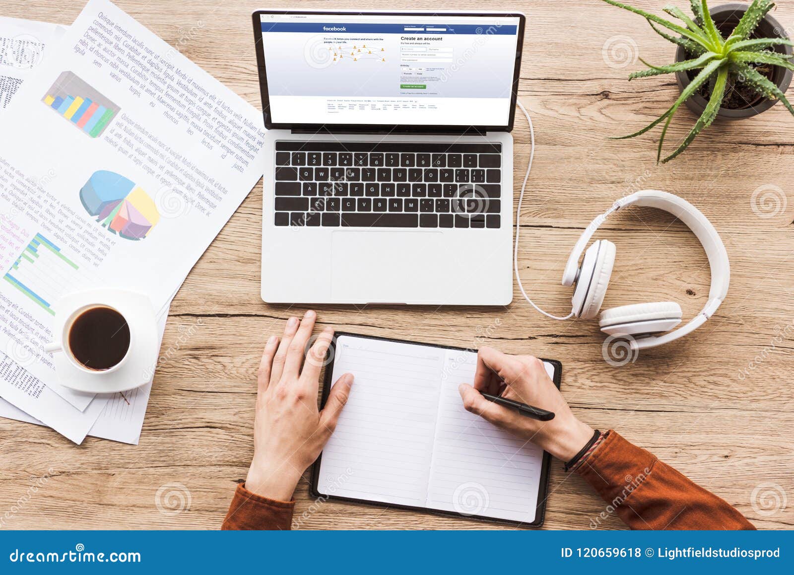 Partial View of Man Making Notes in Notebook at Workplace with Laptop ...