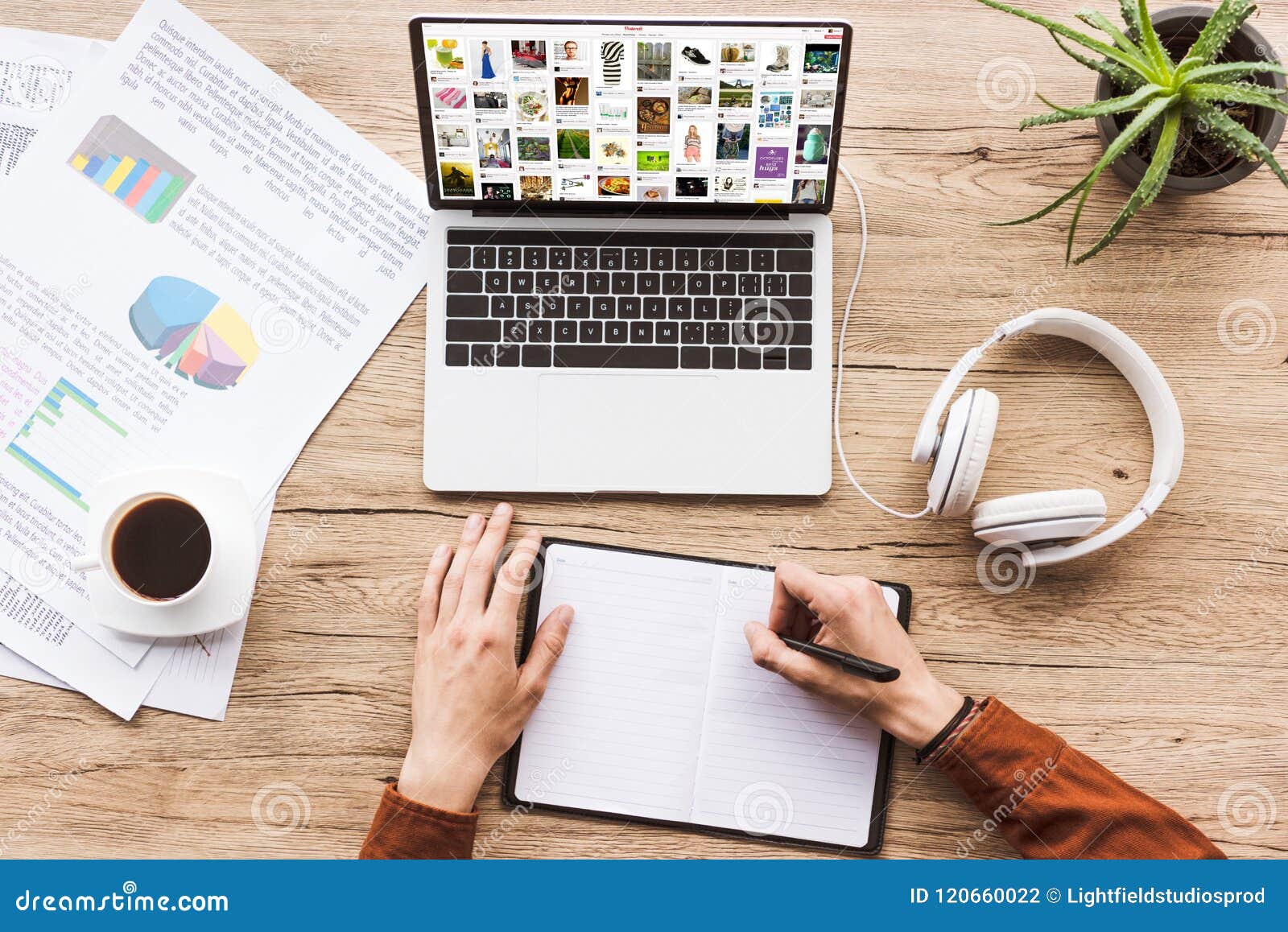 Partial View of Man Making Notes in Notebook at Workplace with Laptop ...