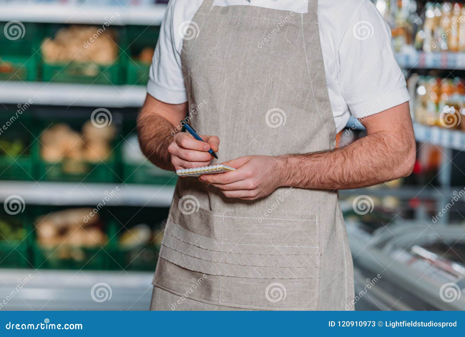 Partial View of Shop Assistant in Apron Making Motes in Notebook Stock ...