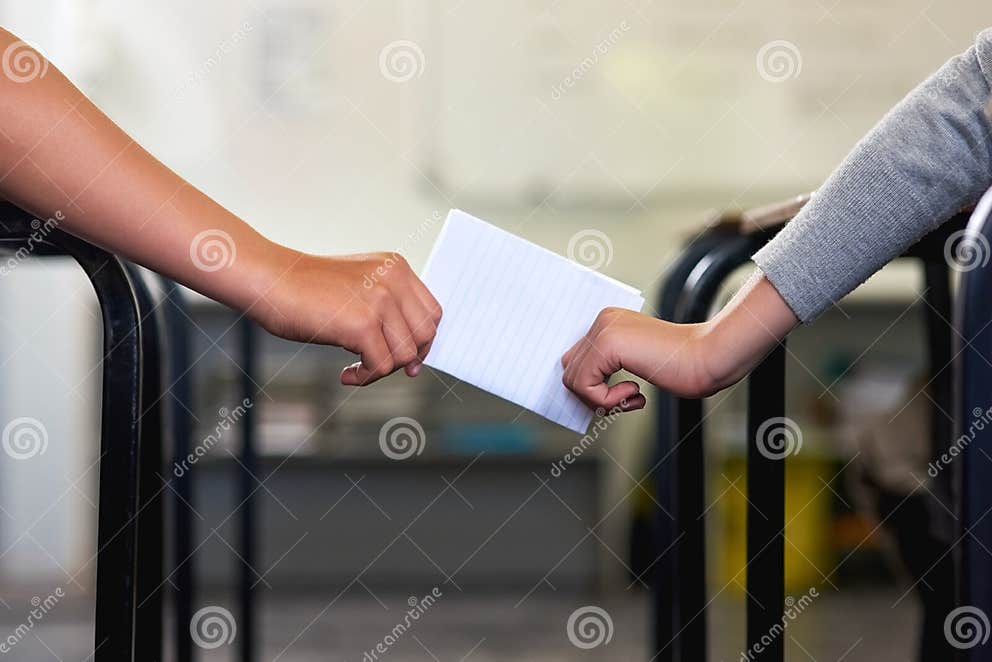 Pass it on. Two Unidentifiable Schoolchildren Passing a Note in Class ...