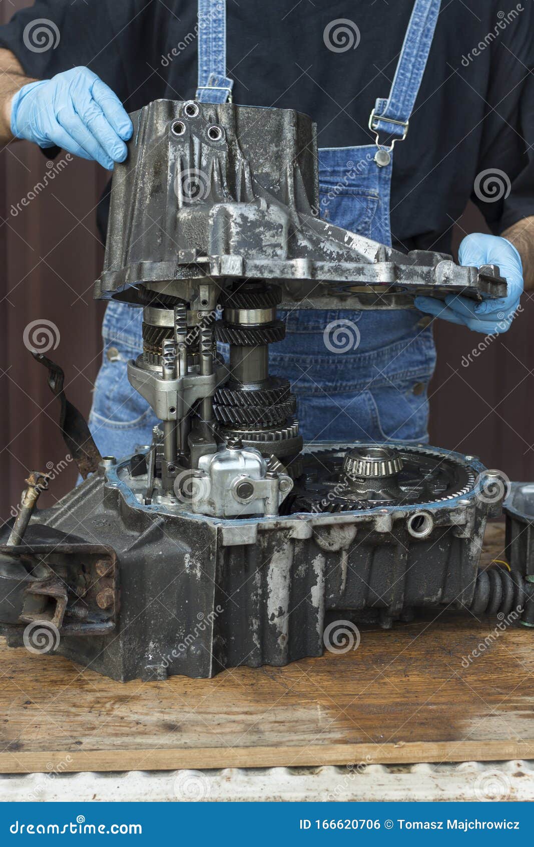 The Passenger Car Gearbox is on the Table. the Mechanic`s Hands Remove ...