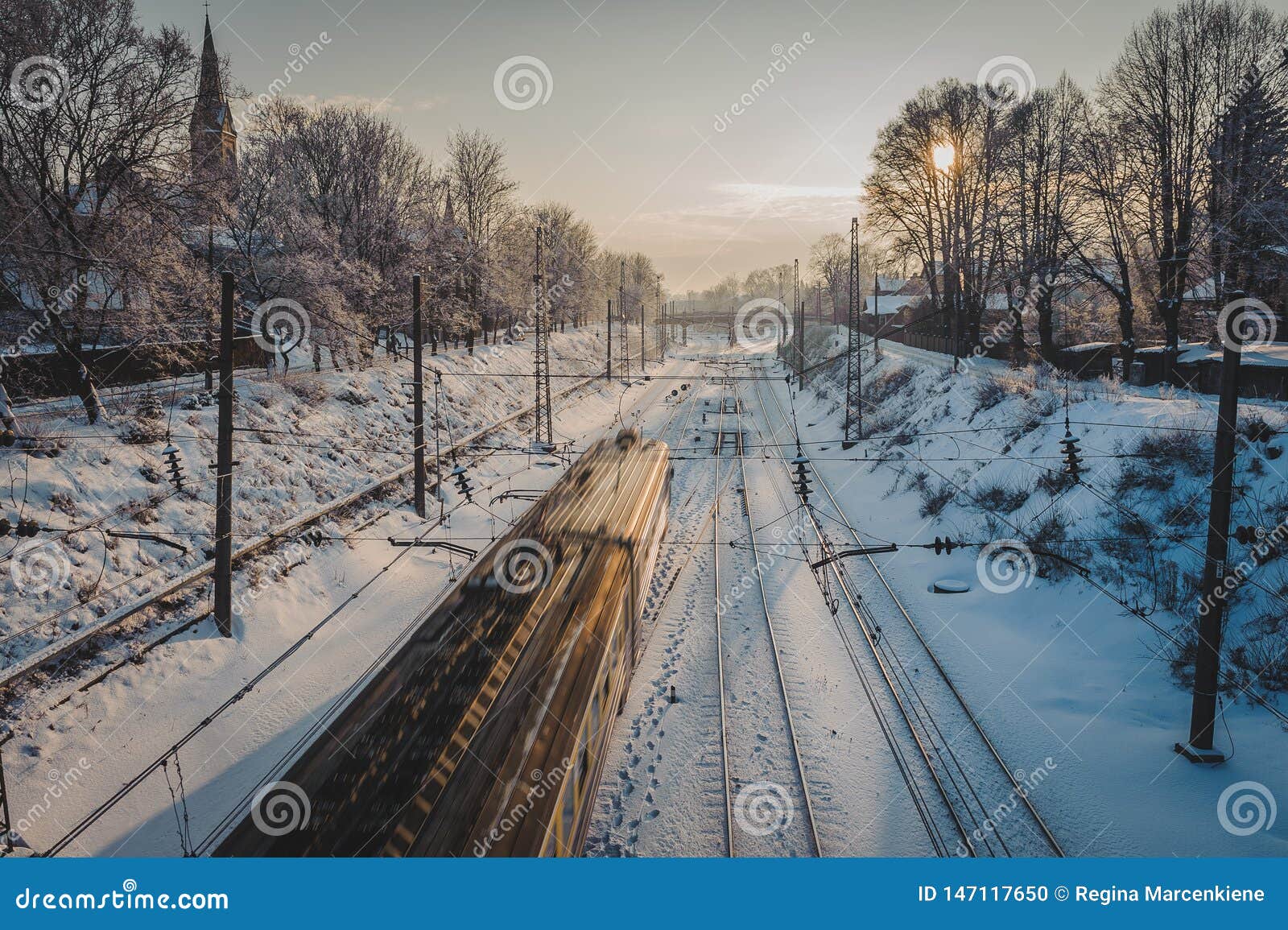 Passenger Electric Train on the Railway at Winter Sunset Behind Trees ...