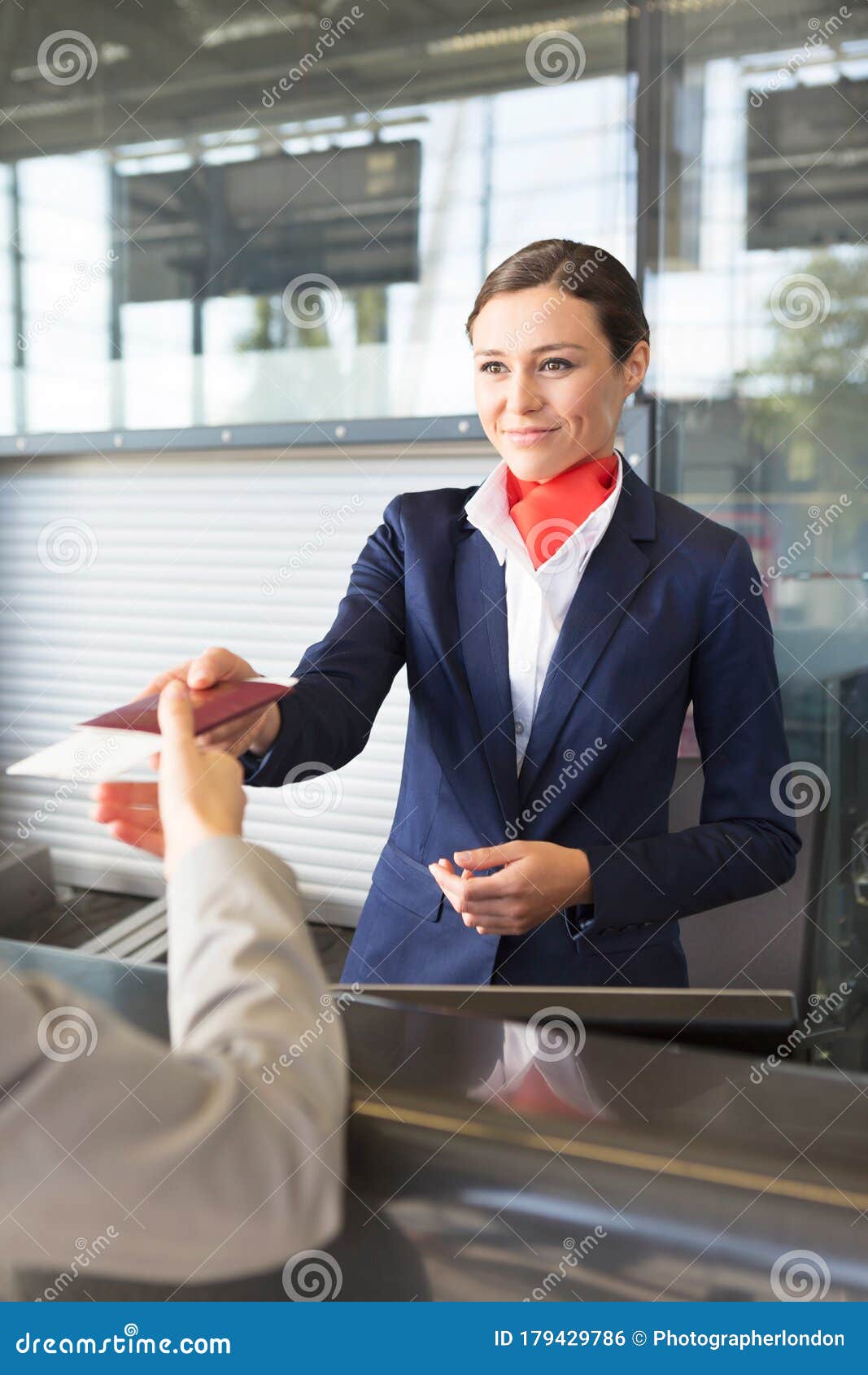 Passenger Service Agent Giving Woman`s Passport And Boarding Pass In