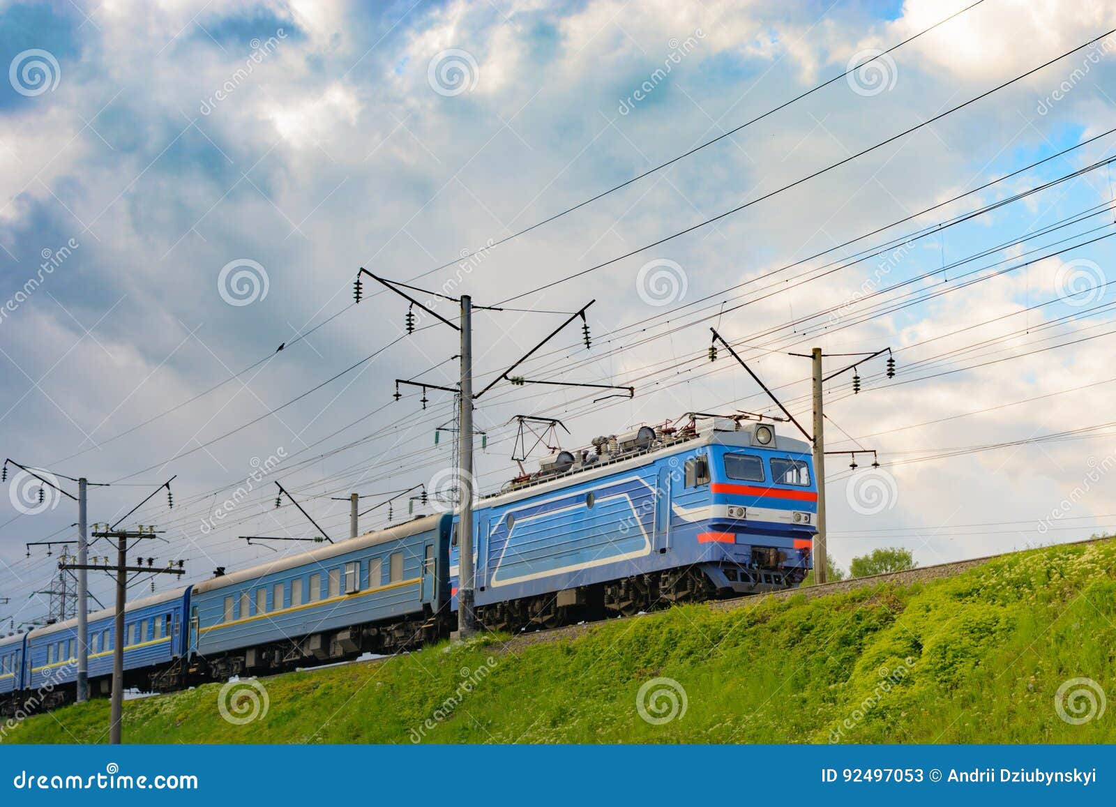 Passenger Train Rides on an Electrified Line Against a Blue Sky Stock ...