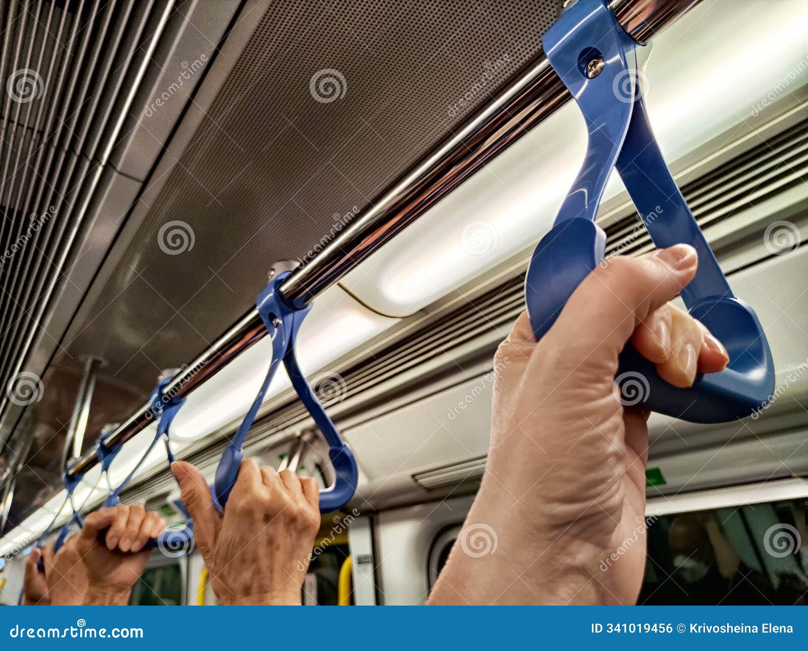 Passengers Holding Safety Straps on a Subway Train in the Evening ...