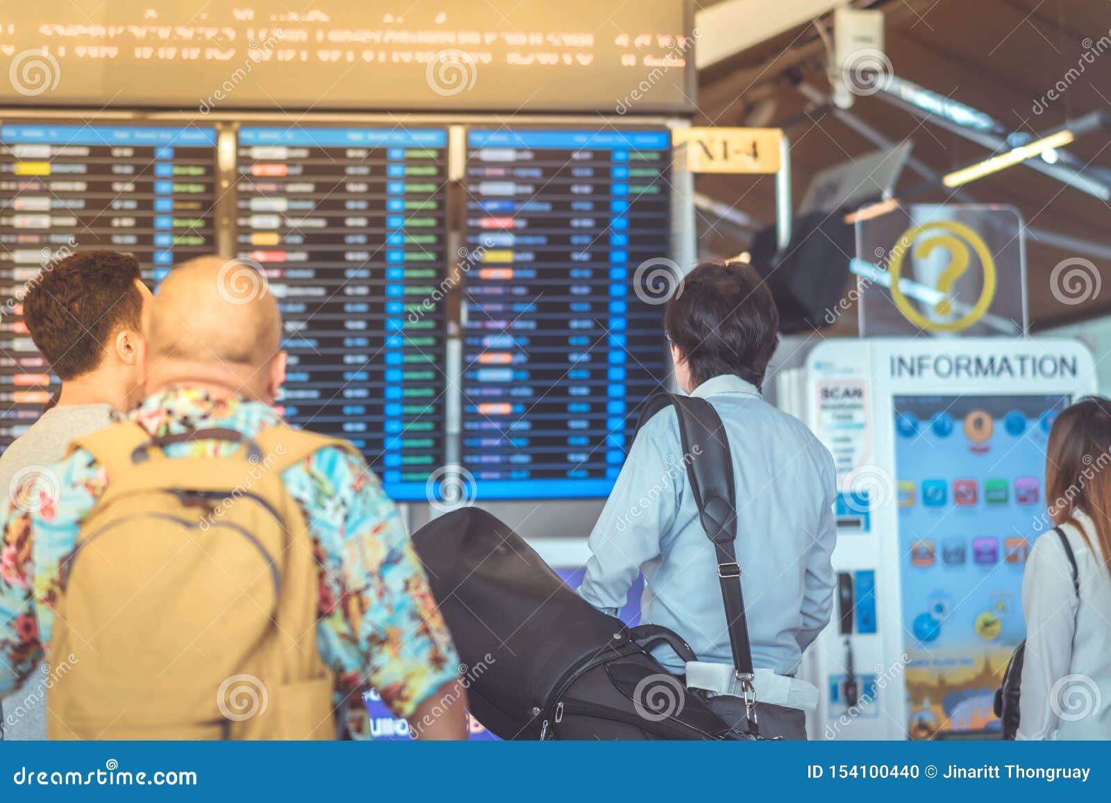 Passengers Looking at the Flight Information Board and Checking Their ...