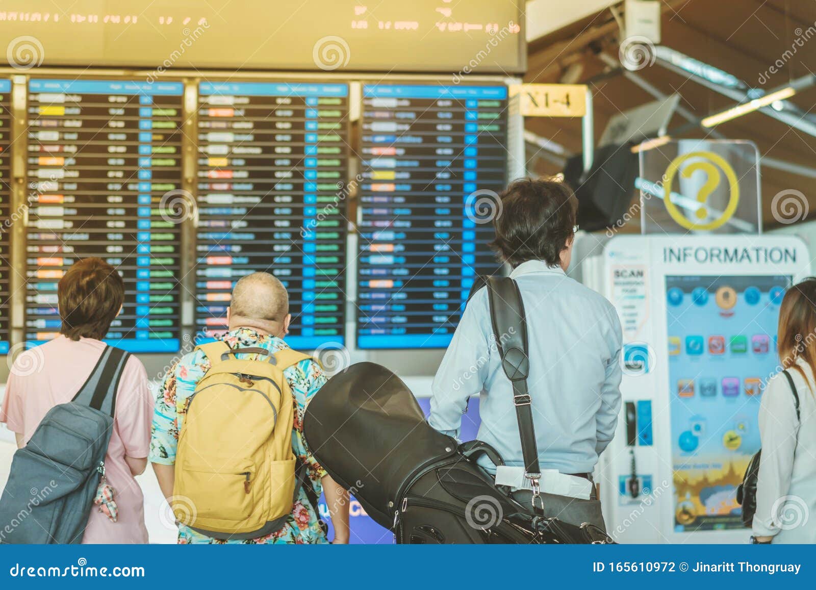 Passengers Looking at the Flight Information Board and Checking Their ...