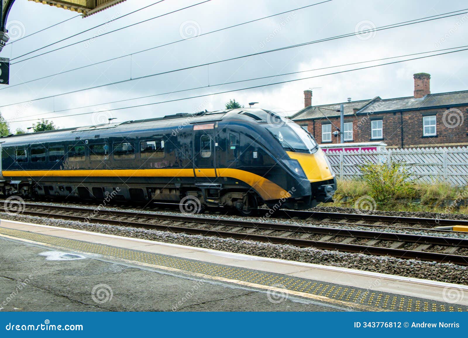 A Passing High Speed Passenger Train Flying Past a Train Station ...
