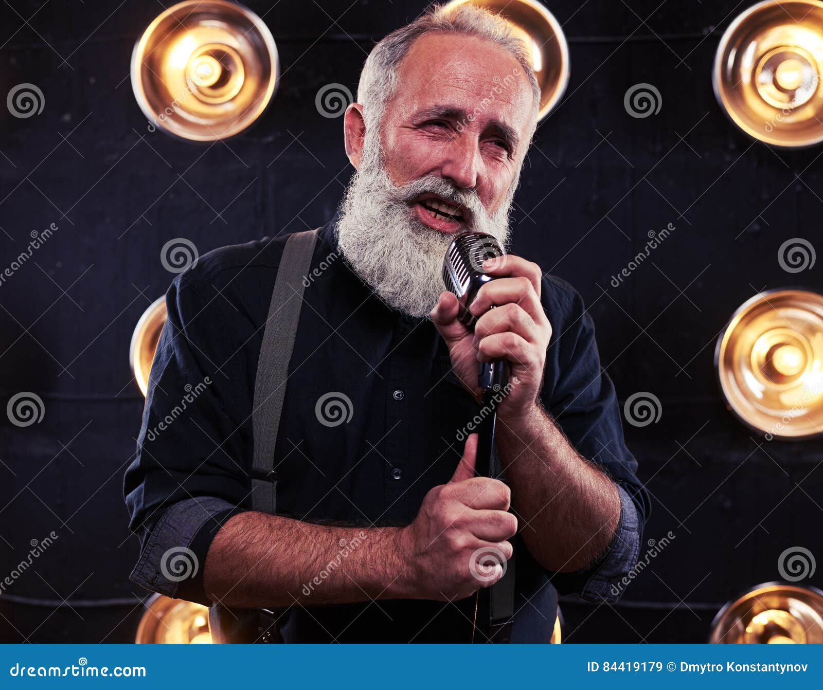 Passionate Performer Singing with a Microphone in a Studio Light Stock ...