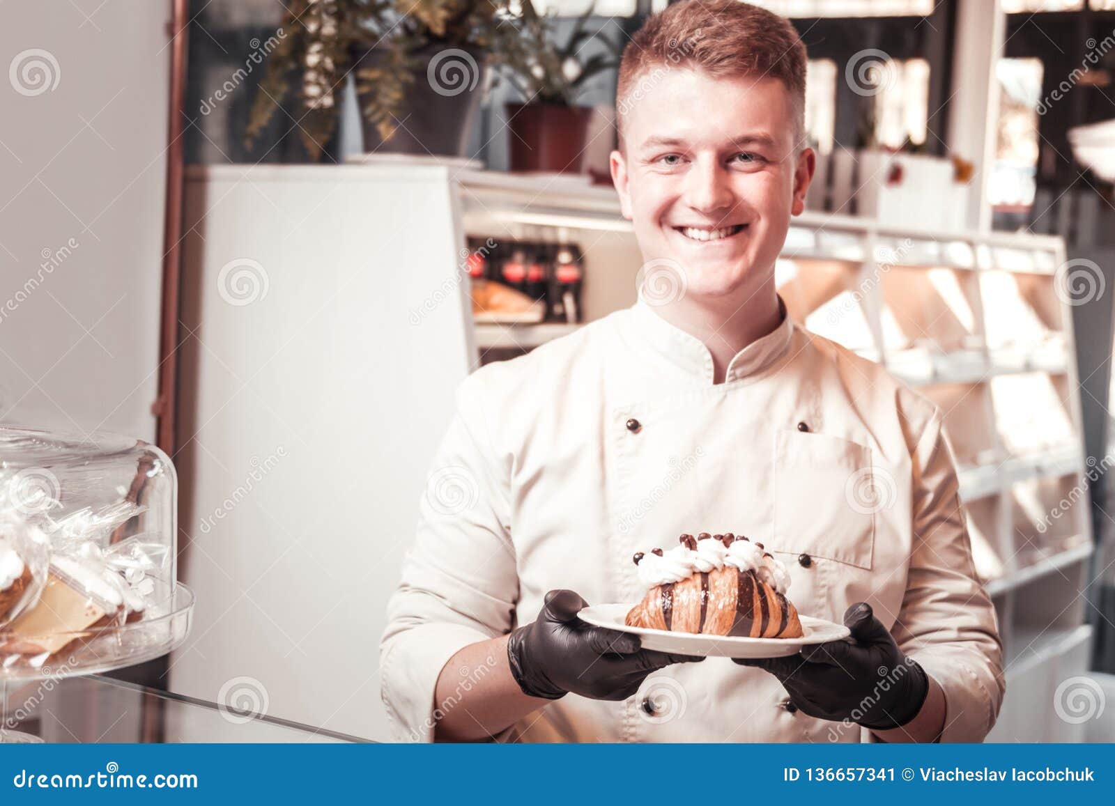 Pasteleiro De Sorriso Que Serve O Croissant Com Um Creme Imagem de ...
