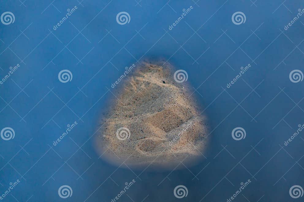 Patch of Sand Visible through a Hole on a Blue Surface Stock Image ...