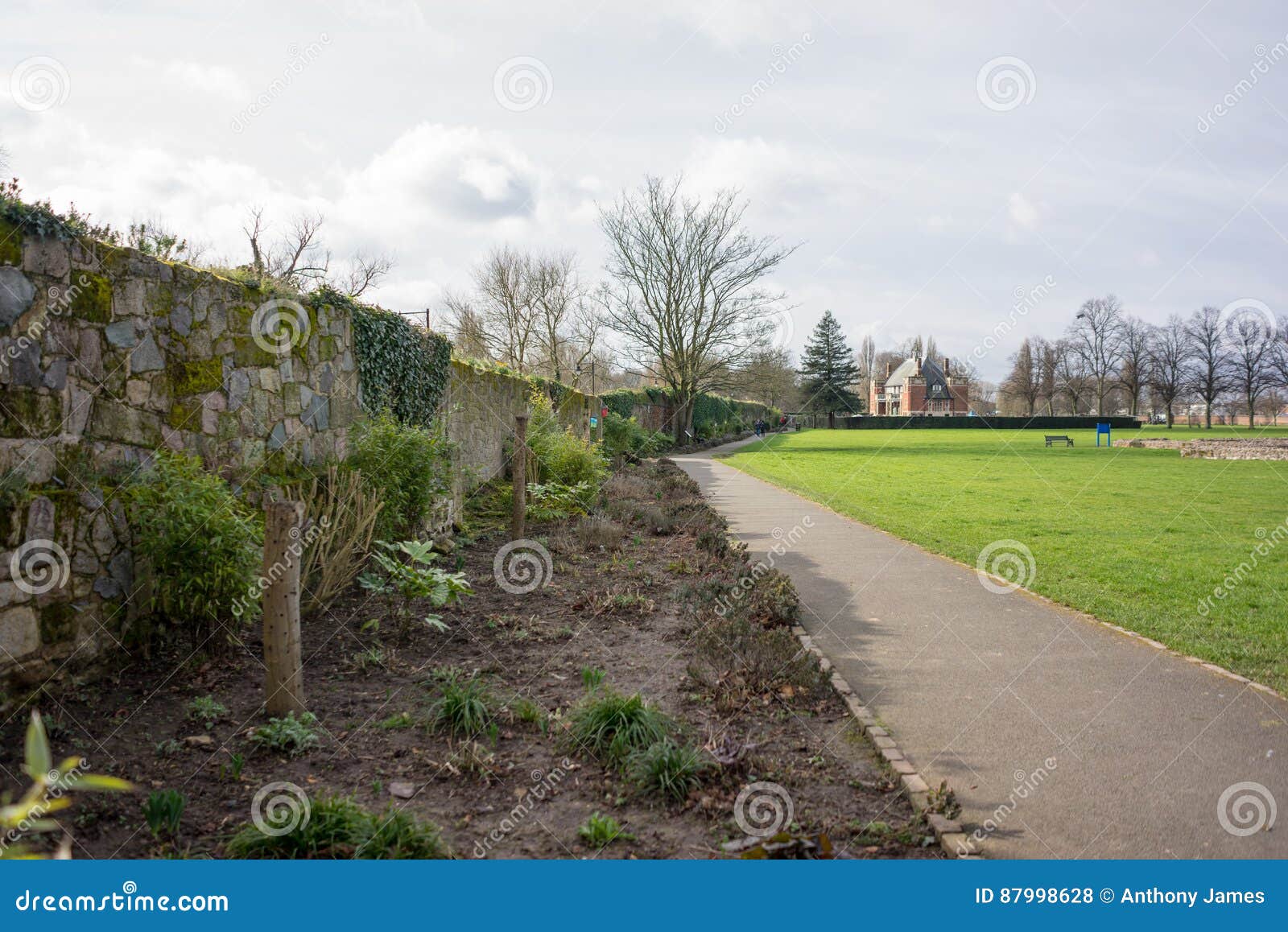 Pathway in a Park Along Side is a Wall and Border Stock Photo - Image ...