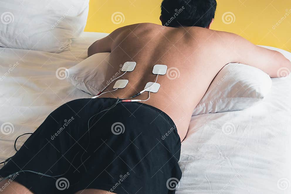 Patient Applying Electrical Stimulation Therapy on Back. Electrical ...
