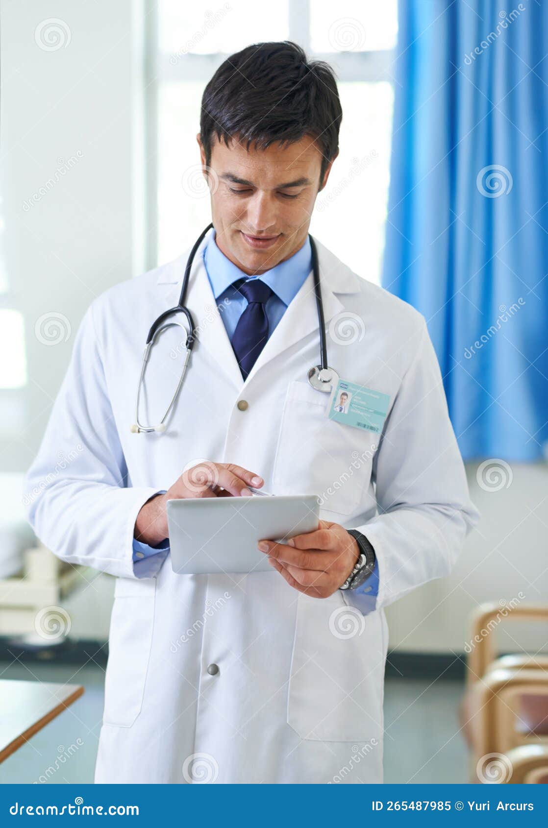 Patient Files at the Swipe of a Hand. a Handsome Young Doctor Using a ...