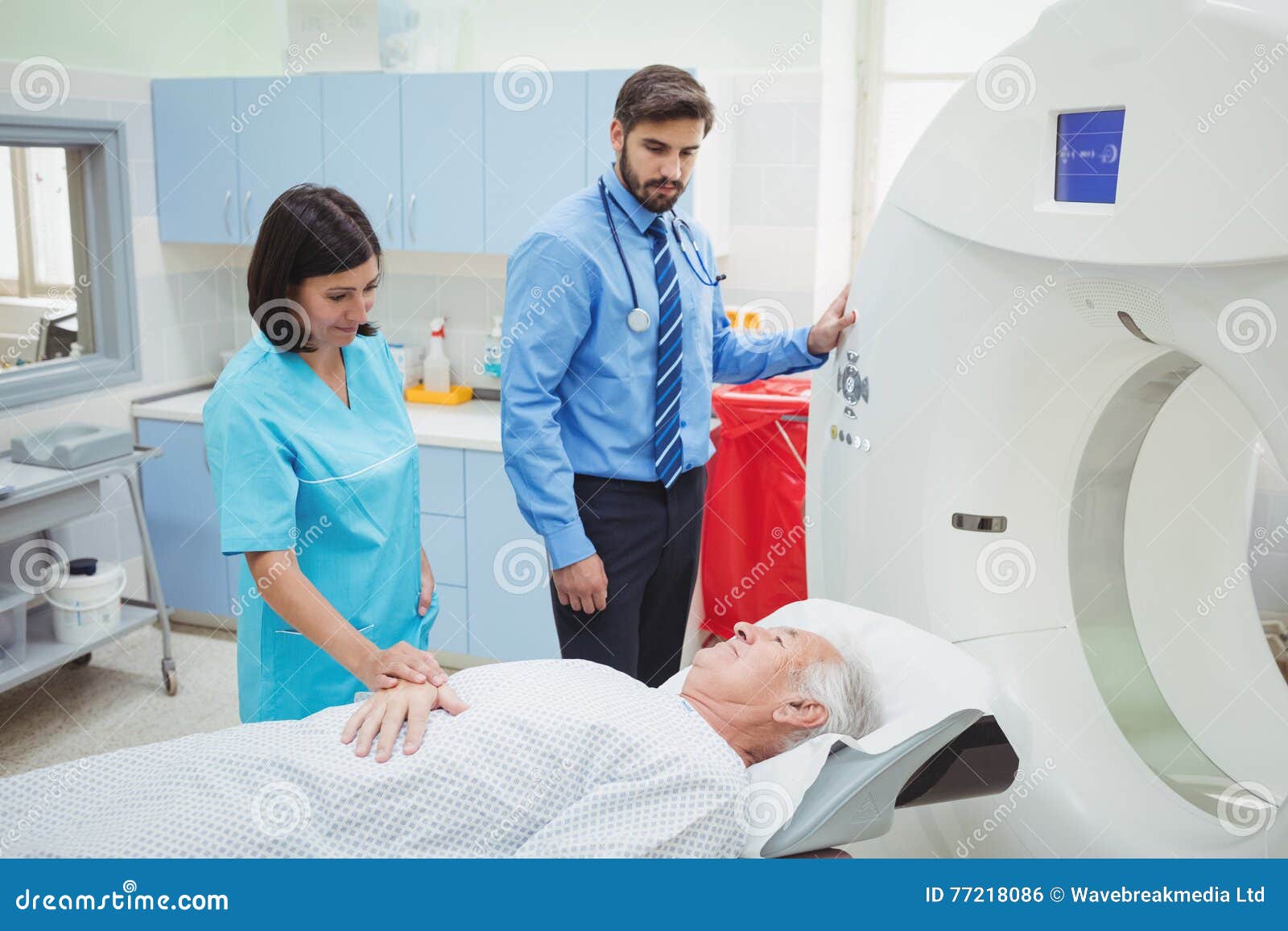 A Patient is Loaded into an Mri Machine while Doctor and Technician ...