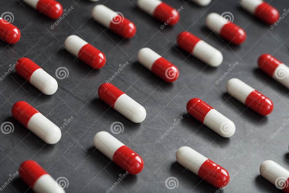 A Pattern of Red and White Pill Capsules on a Black Background ...