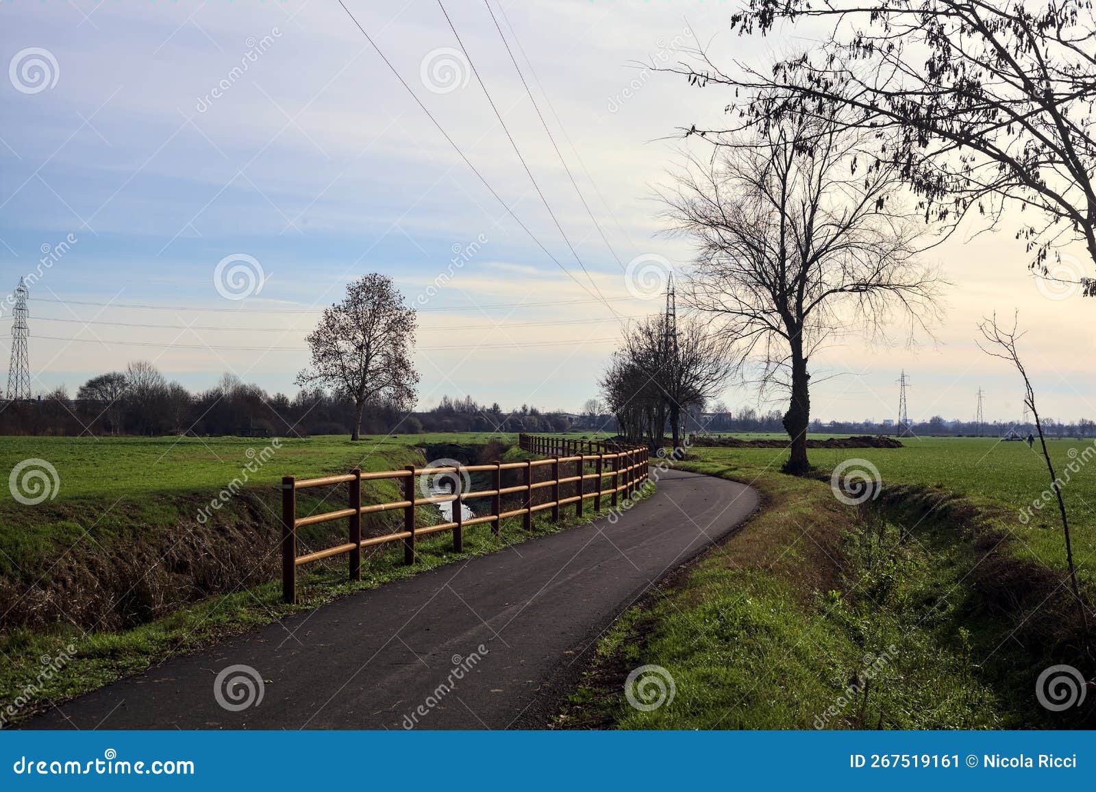 Paved Trail Bordered by a Railing and a Stream of Water between Fields ...