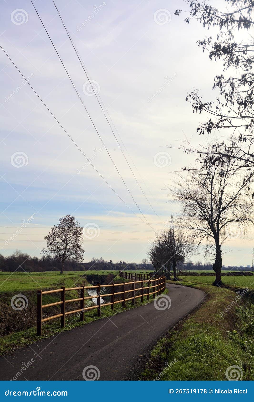 Paved Trail Bordered by a Railing and a Stream of Water between Fields ...