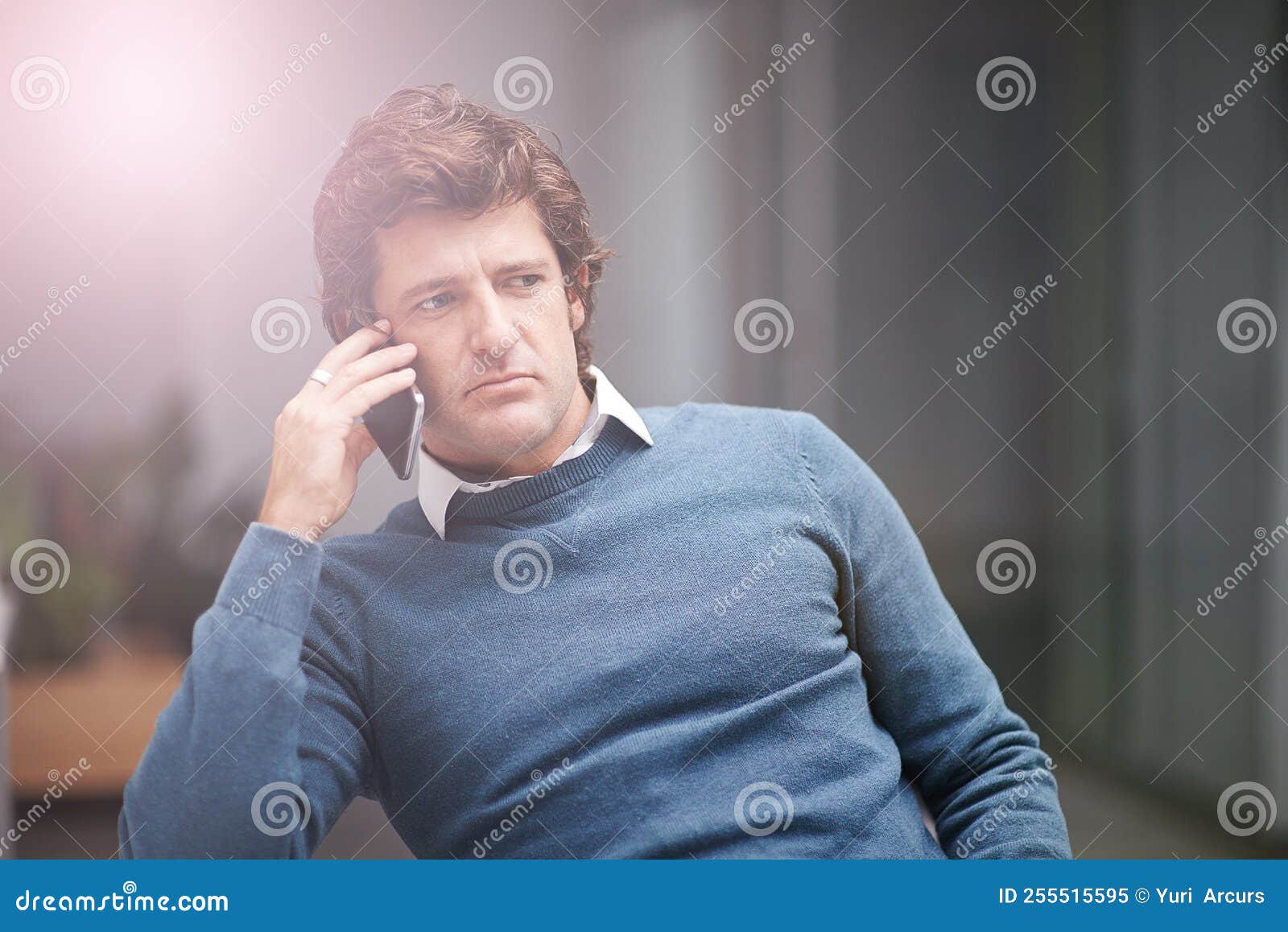Paying Close Attention To the Needs of His Client. a Businessman Using a Phone in the Office ...