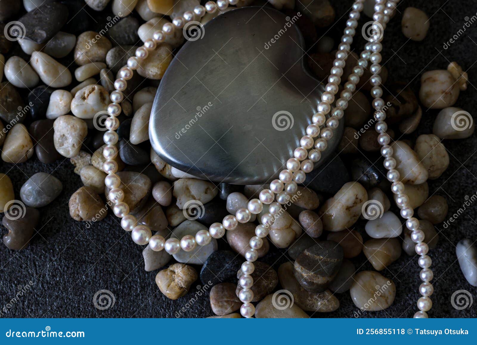 Pearl Necklace and Heart Shaped Metal Object Isolated on Stone Pattern ...