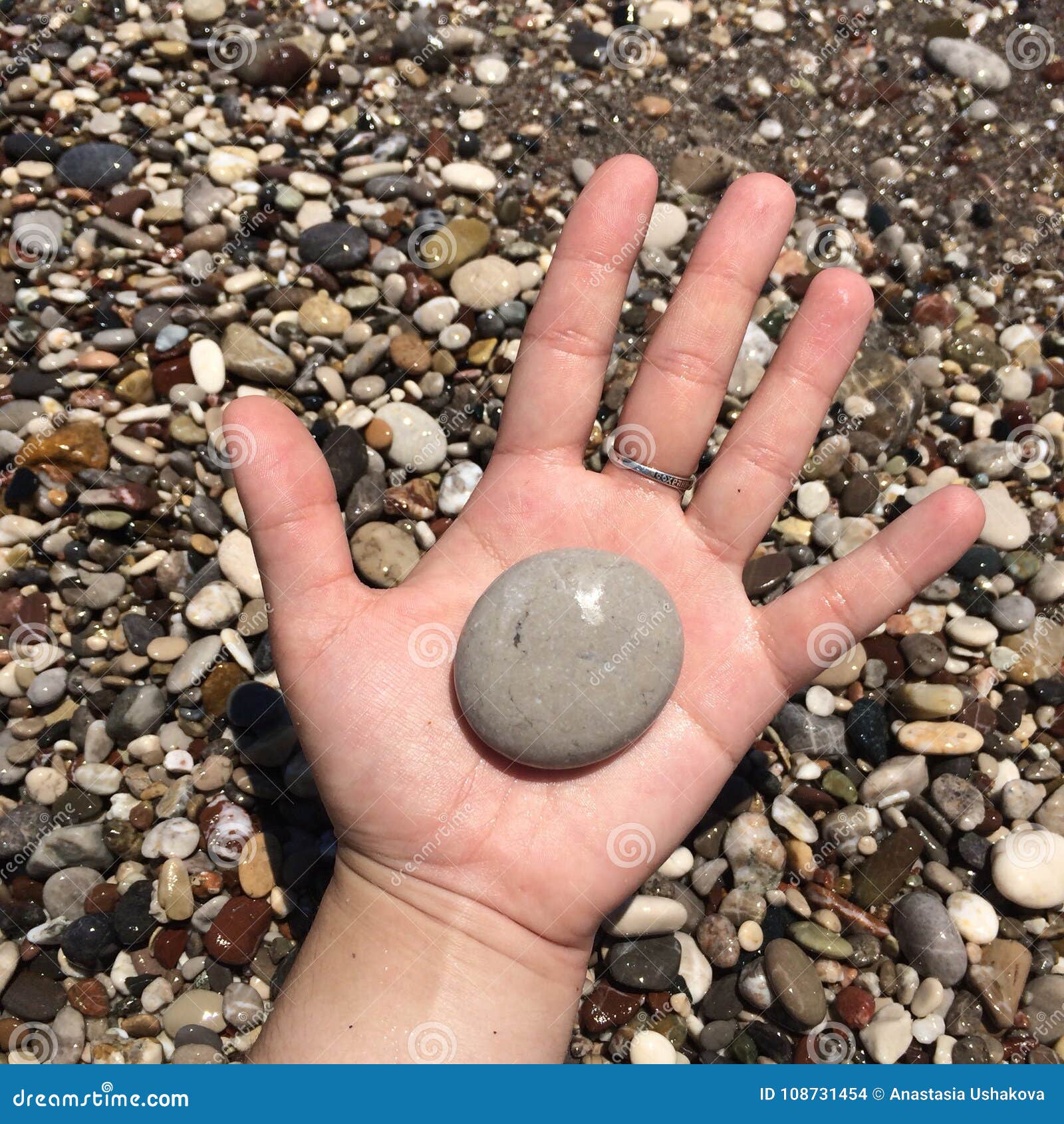 Pebble in hand stock photo. Image of wave, blue, light - 108731454