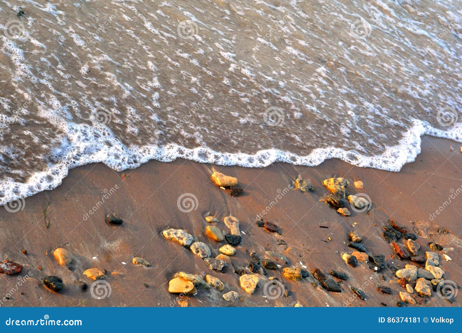 Pebbles beach at sunset stock image. Image of coastline - 86374181