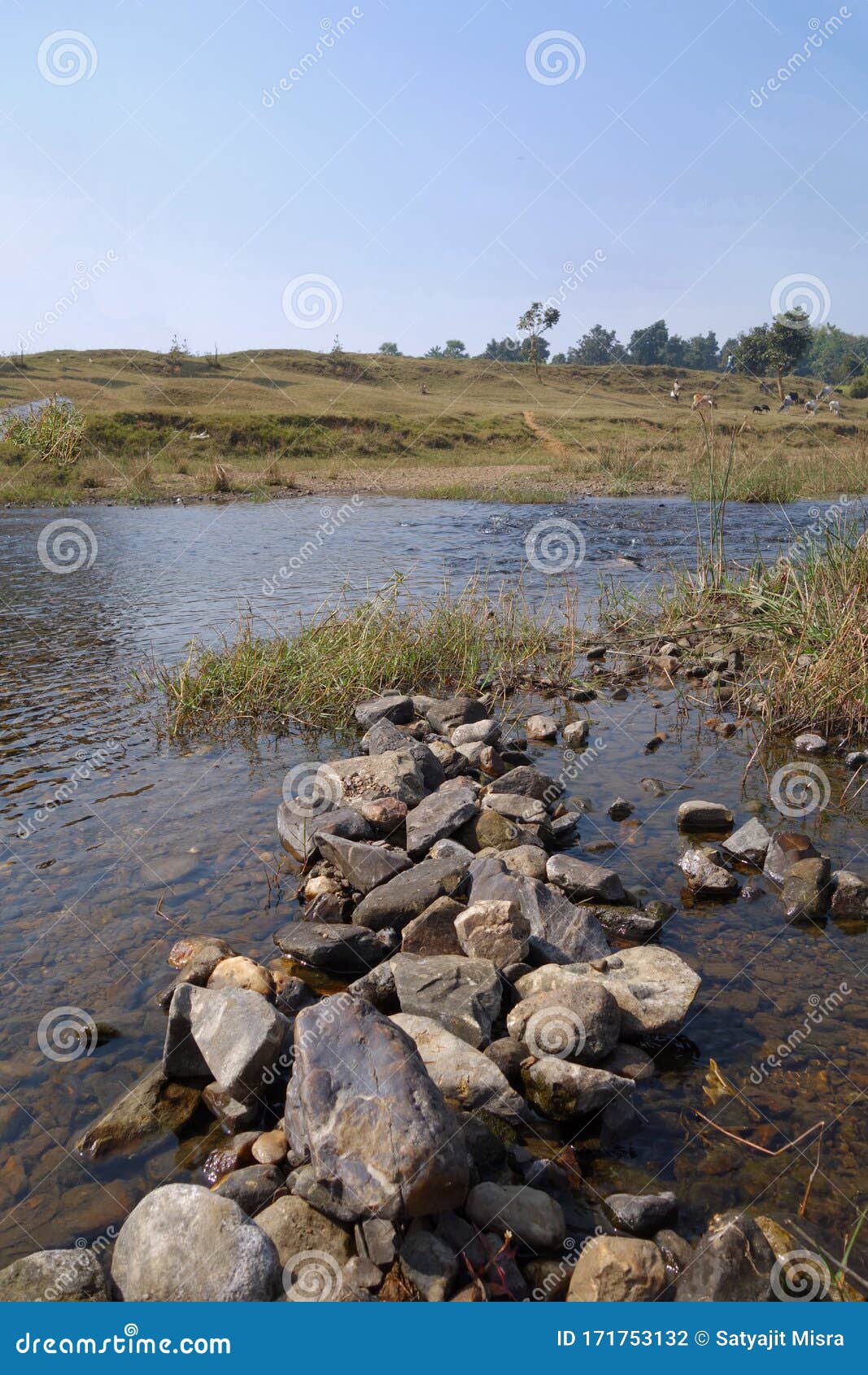 Pebbles at a River Bank and Water Flows with Blue Sky As Background ...