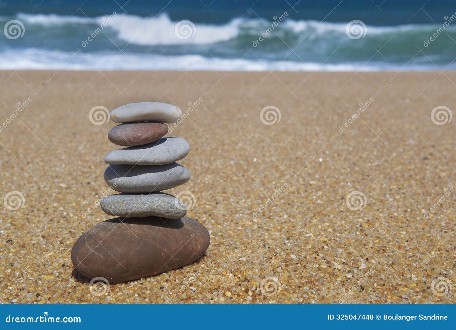 Pebbles Stacked on a Sandy Beach in Front of Ocean Stock Photo - Image ...