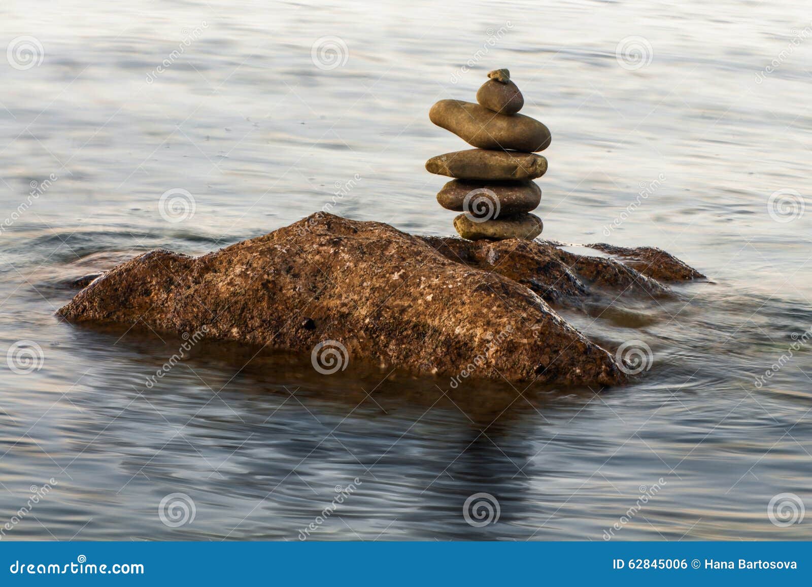 Pebbles stacked in water stock photo. Image of peace - 62845006