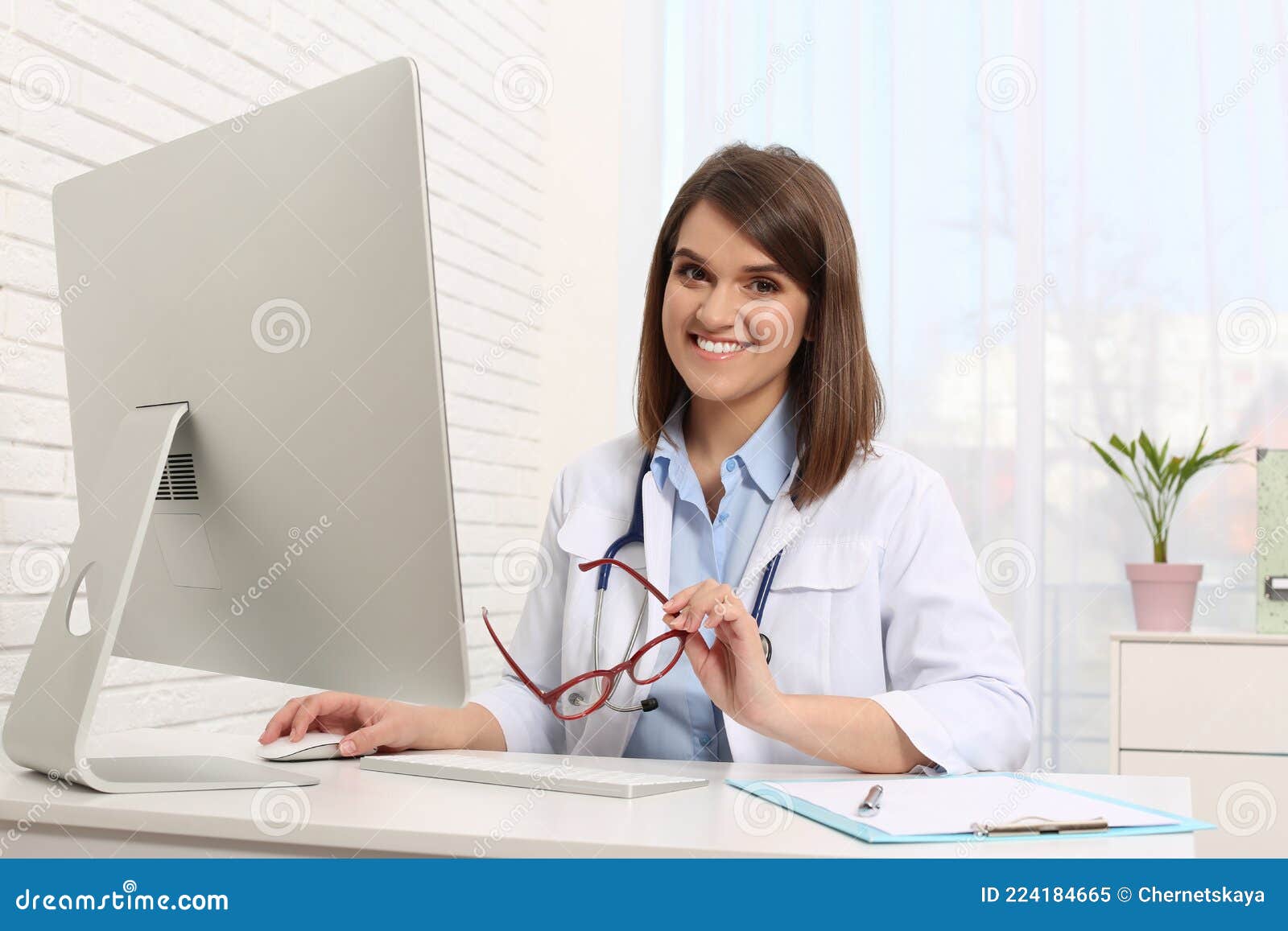 Pediatrician Working with Computer at Table Stock Image - Image of ...