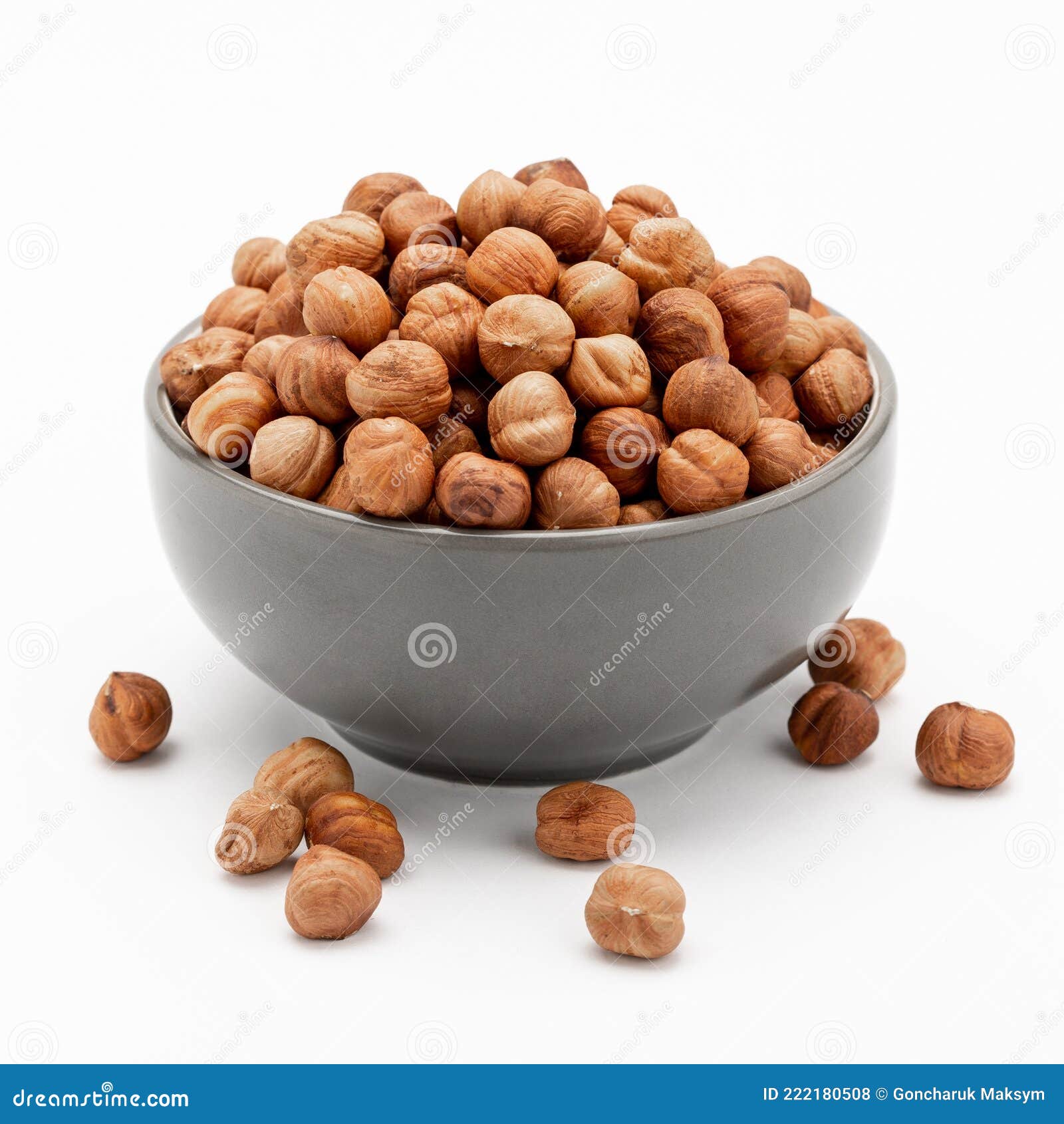 Peeled Hazelnuts in a Bowl and a Few Nuts Scattered Around on a White ...