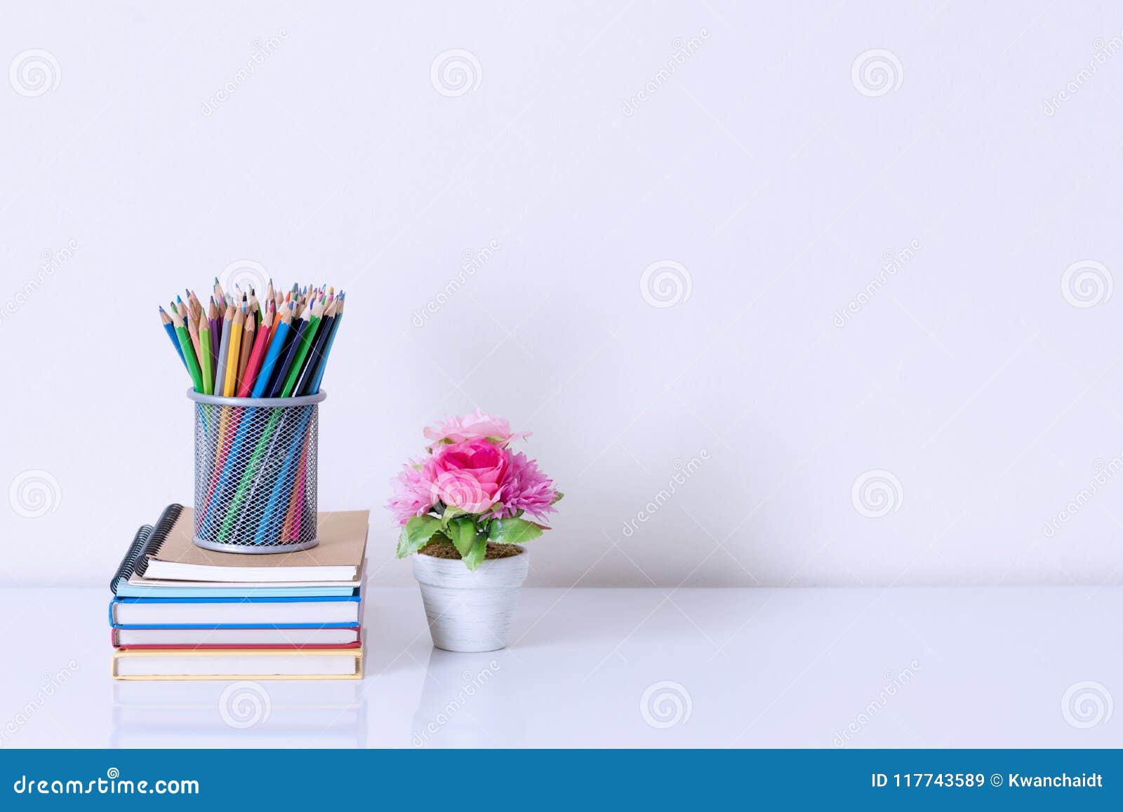 Pencil Box on Book Stack and Artificial Flower Pot on White Table ...