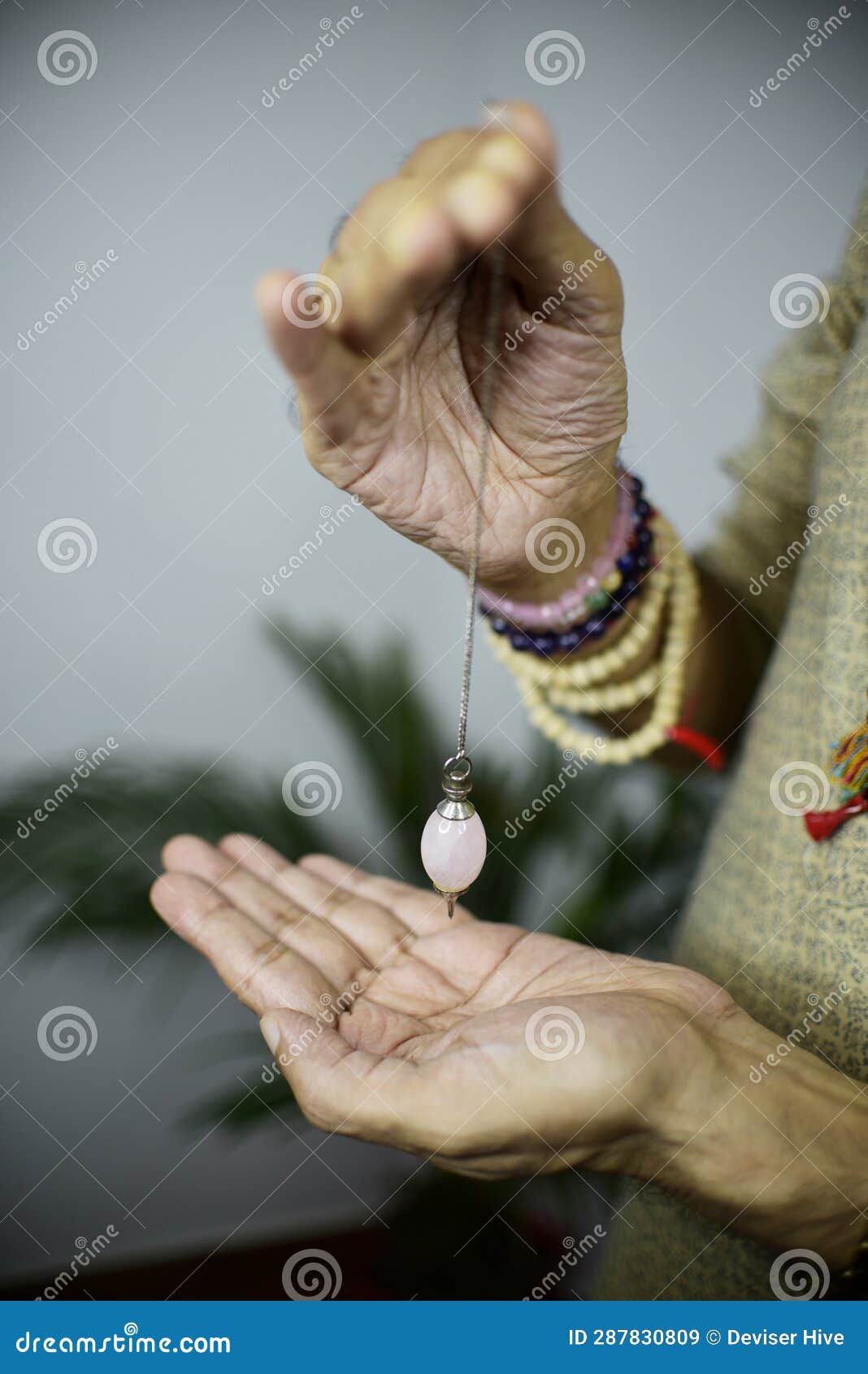 Pendulum Dowsing On An Isolated White Background With An Amethyst ...