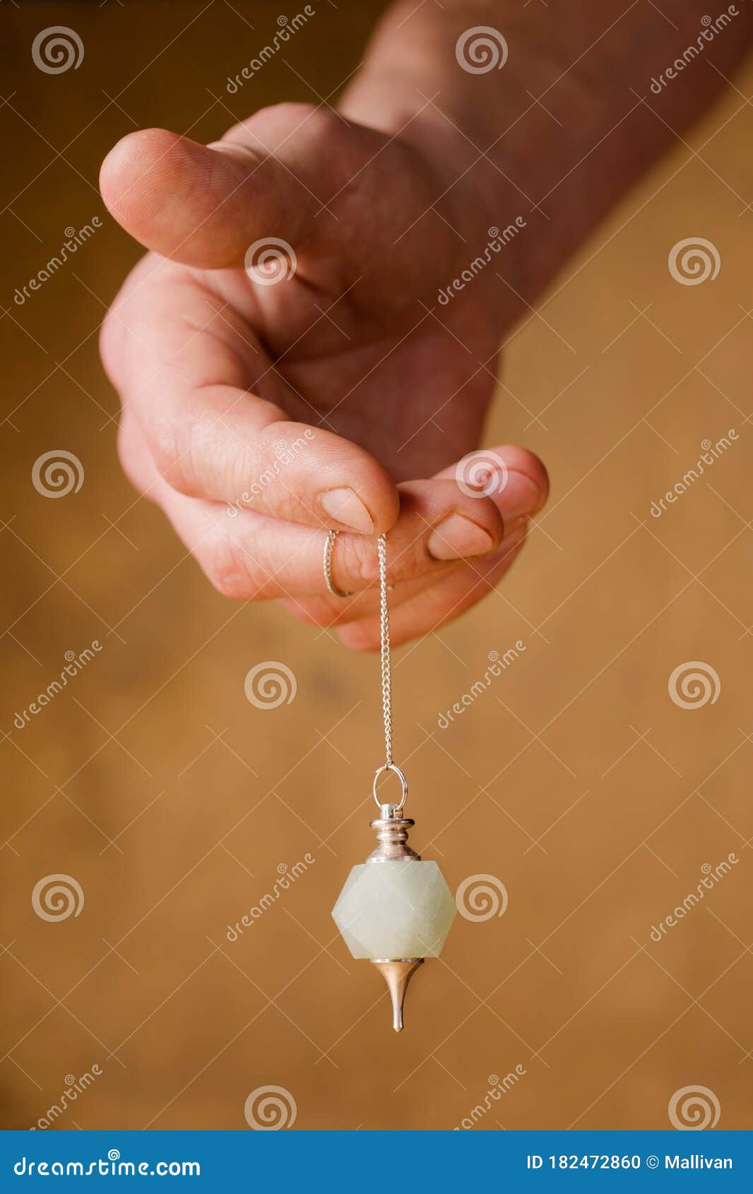 The pendulum in the hand stock photo. Image of hand - 182472860