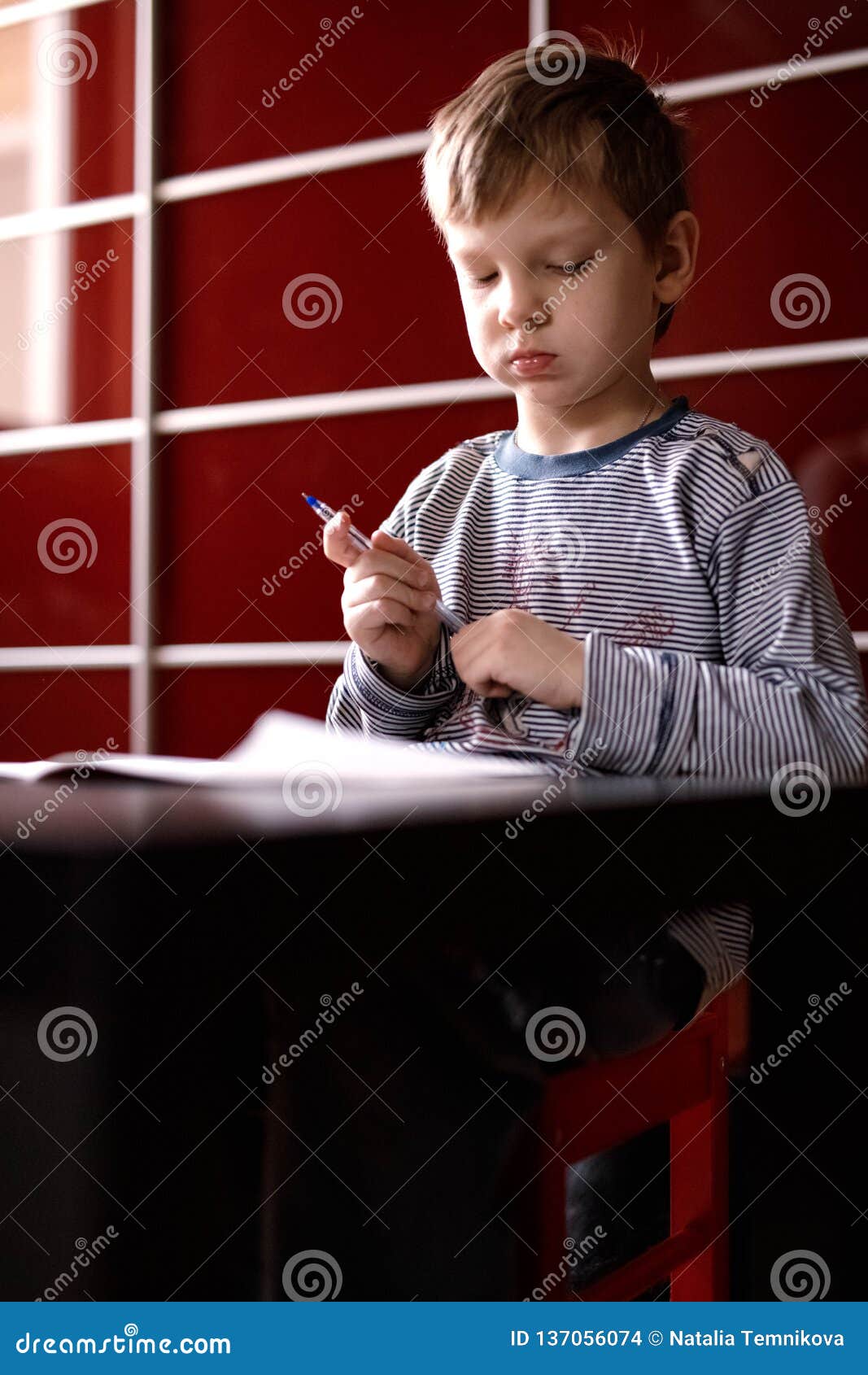 Pensive Boy in a Red Chair at the Table Stock Photo - Image of fashion ...