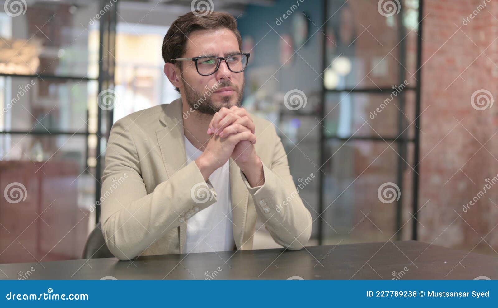 Pensive Young Man Sitting at Work Thinking Stock Photo - Image of ...