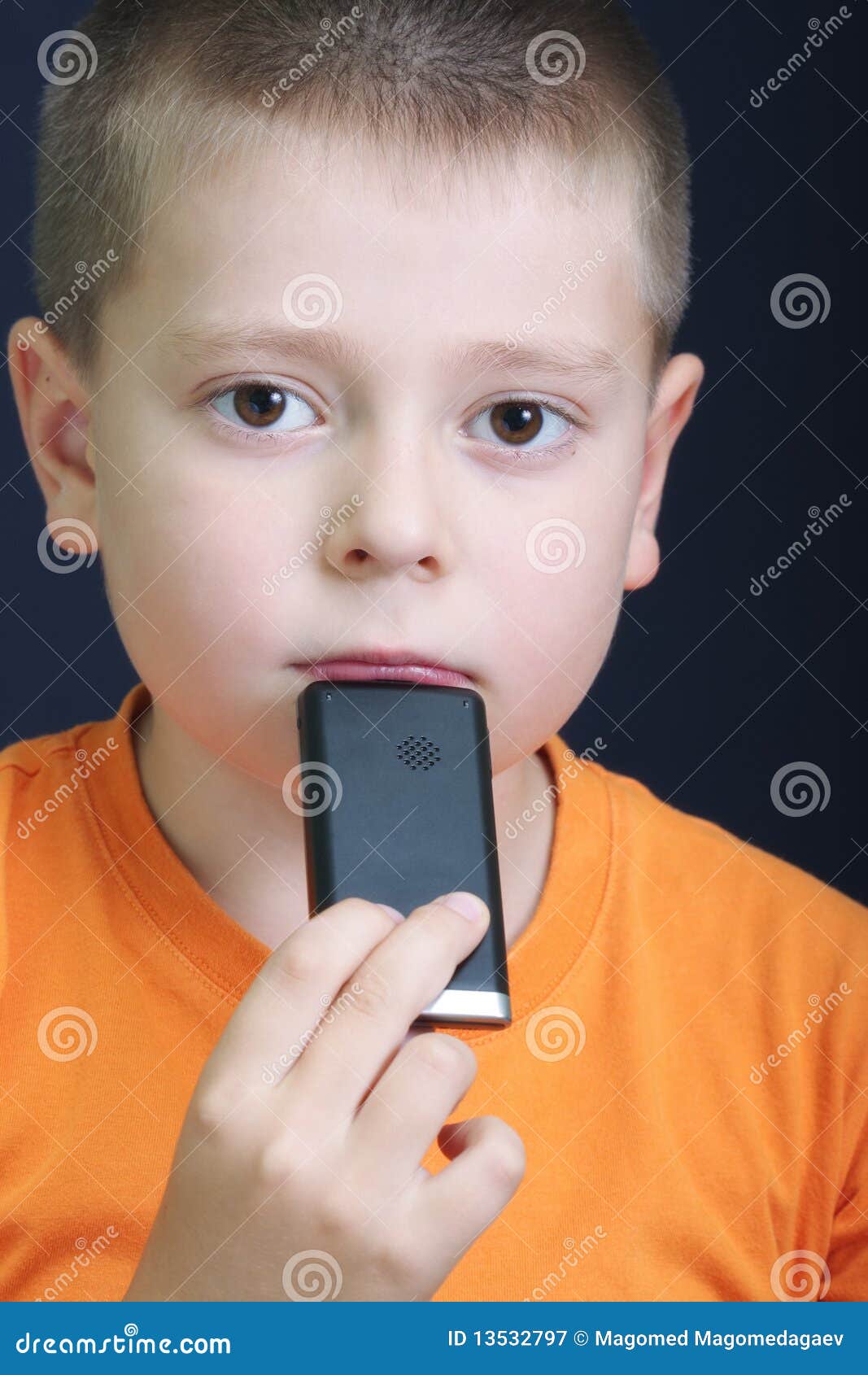 Pensive Kid in Orange with Cellphone Stock Image - Image of serious ...