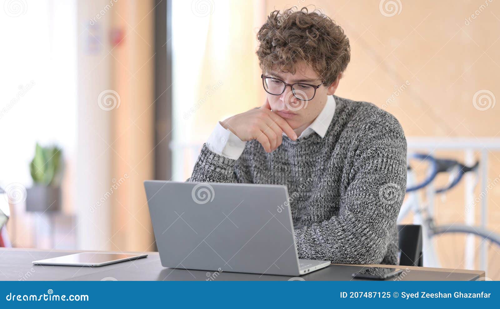 Pensive Young Man with Laptop Thinking at Work Stock Image - Image of ...