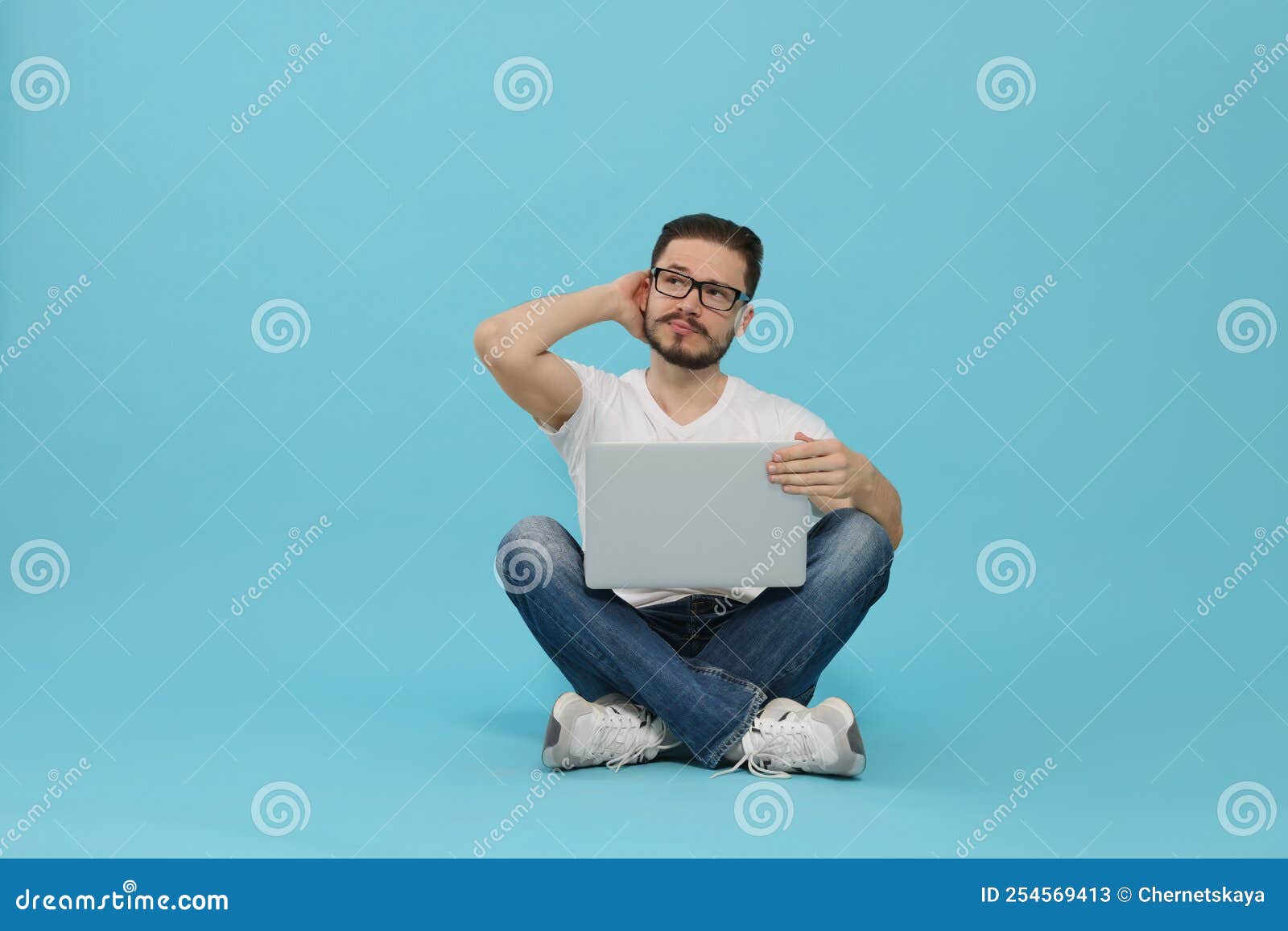 Pensive Man Sitting and Using Laptop on Light Blue Background Stock ...