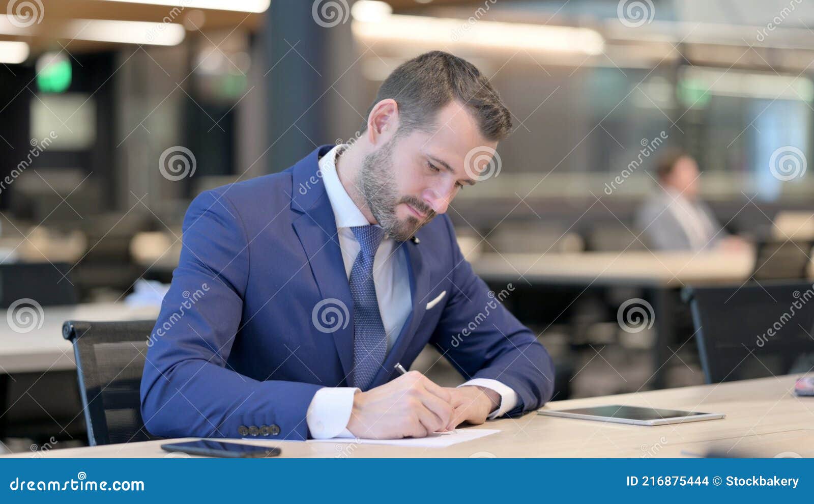 Pensive Middle Aged Businessman Writing on Paper, Thinking Stock Photo ...