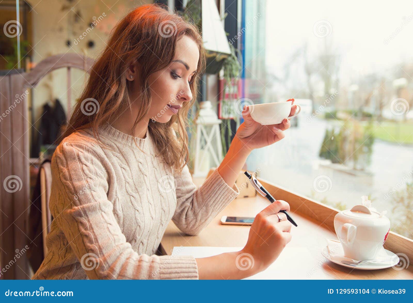 Pensive Student Studying and Learning Taking Notes Drinking Tea in a ...