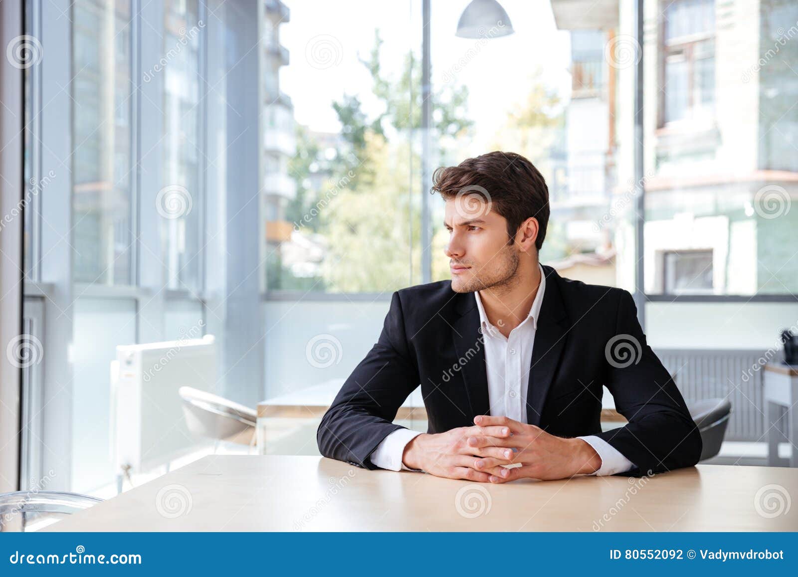 Pensive Young Businessman Sitting and Thinking in Office Stock Photo ...