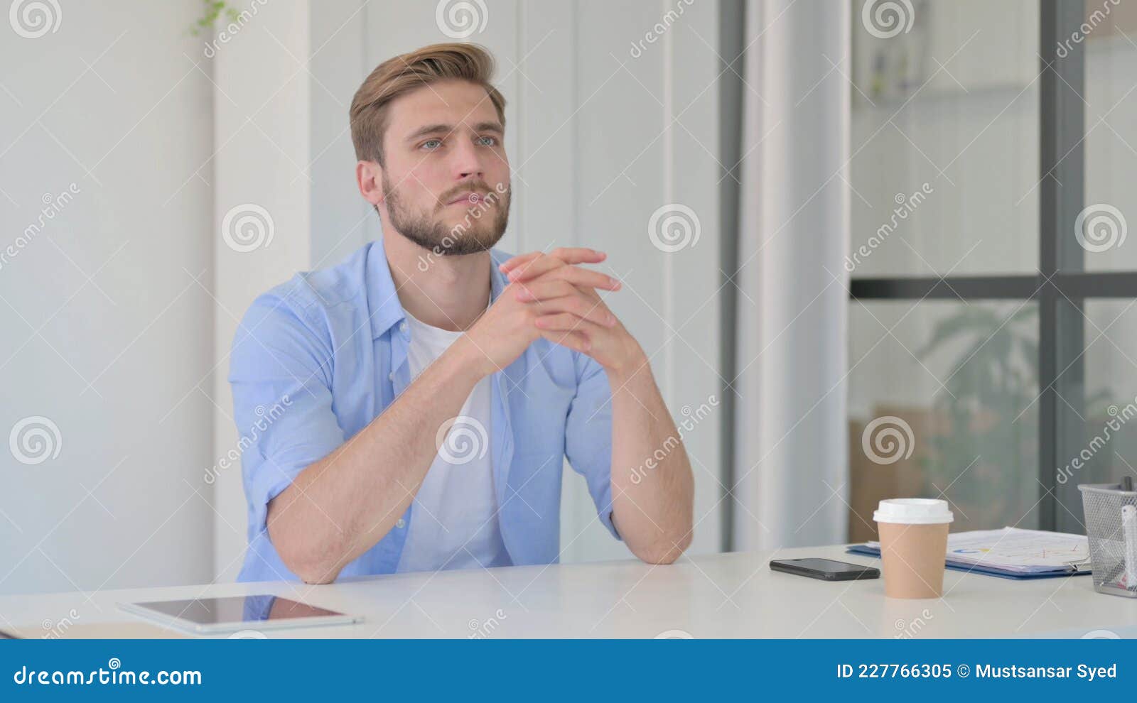 Pensive Young Man Sitting in Office Thinking Stock Image - Image of ...