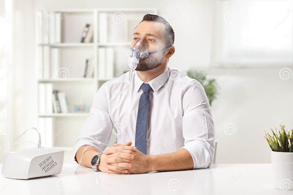 Pensive Young Man Using a Nebulizer with Vapor Mist Stock Photo - Image ...