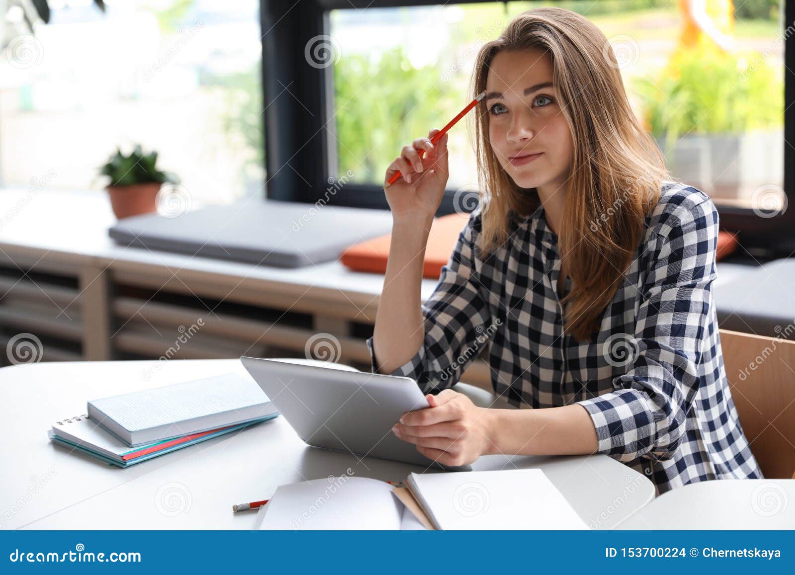 Pensive Young Woman Studying with Tablet at Table Stock Photo - Image ...