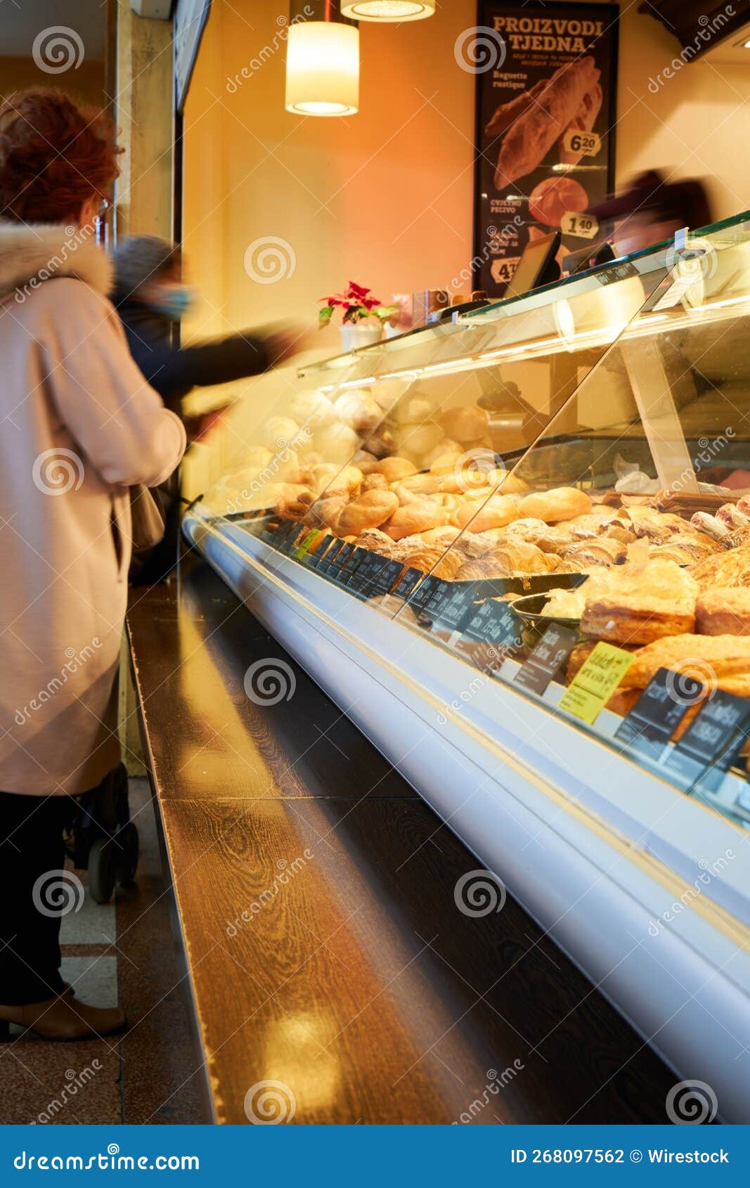 People Buying Fresh Bread and Buns in Front of a Display Cabinet ...