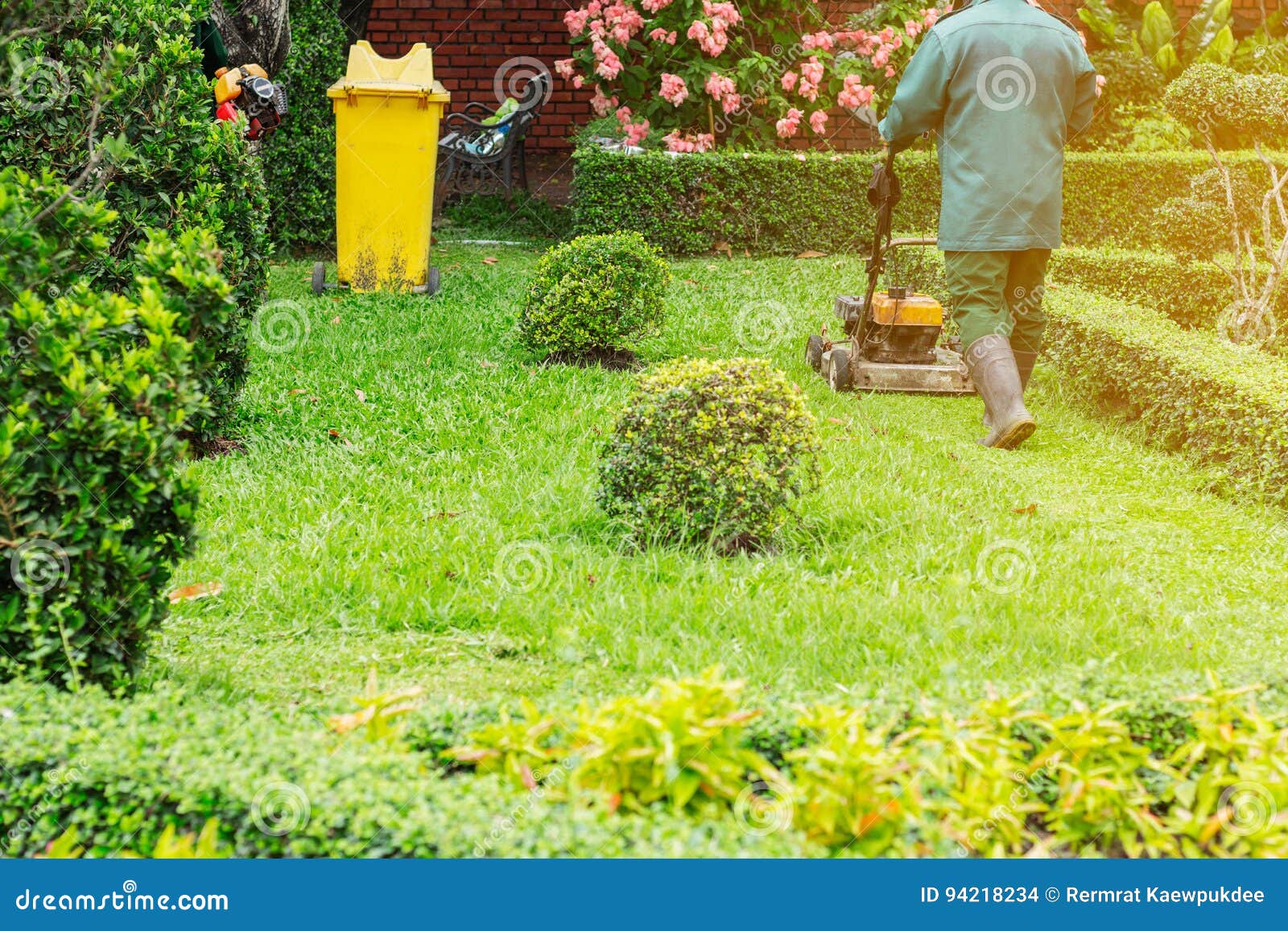 People are cutting grass. stock photo. Image of park - 94218234