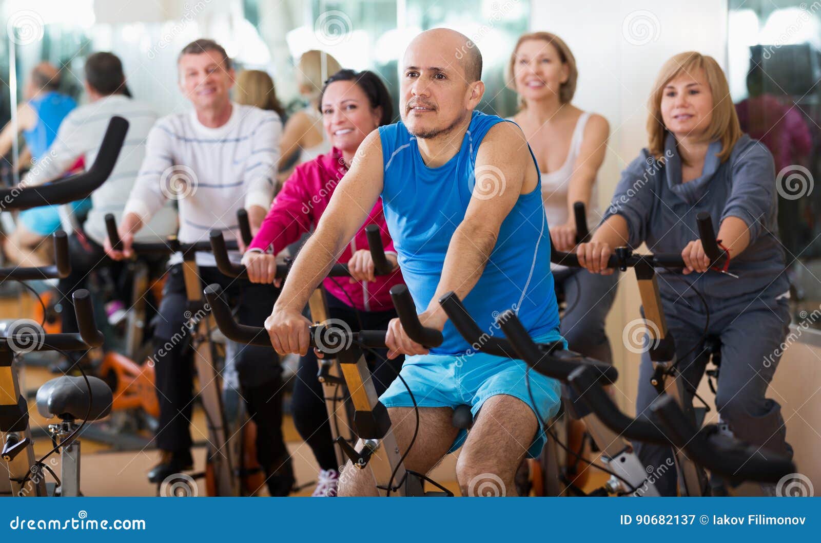People cycling in a gym stock image. Image of exercising - 90682137